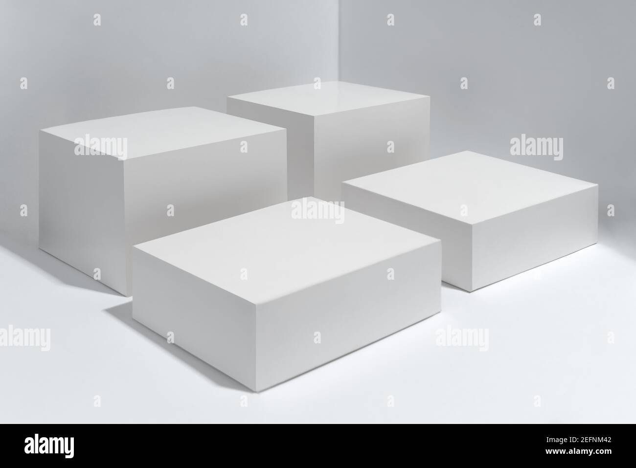 Four white cubes boxes on white background Stock Photo - Alamy