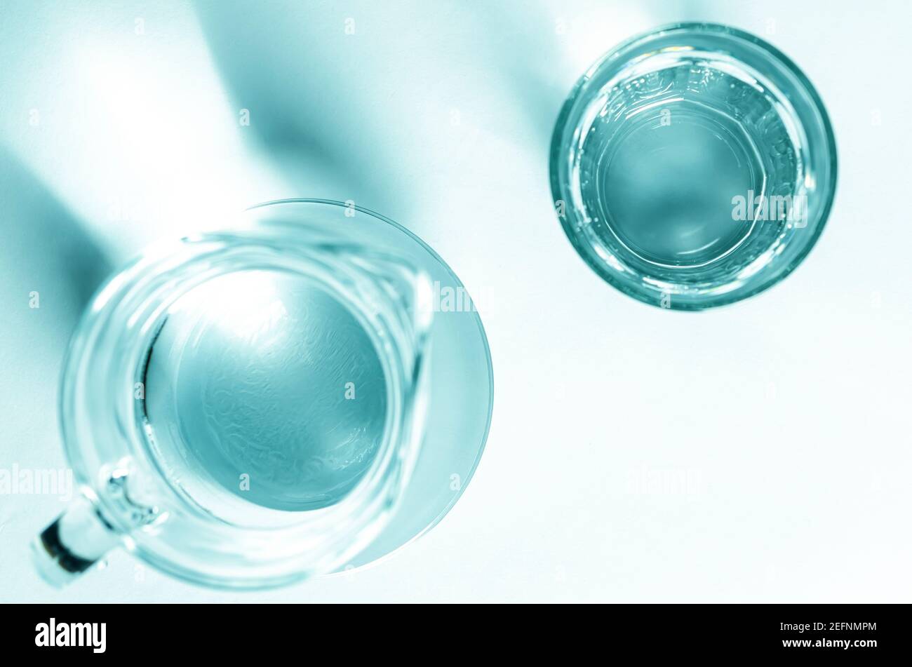 Pure clear water in a glass and jug stands on a white background ...