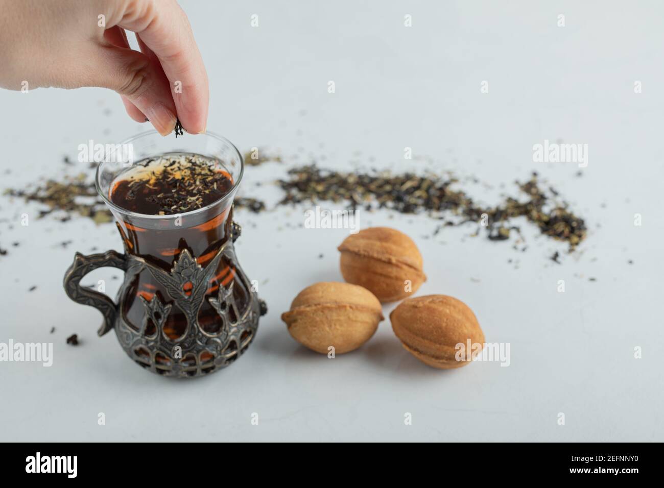 A cup of herbal tea with sweet walnut shaped cookie Stock Photo - Alamy