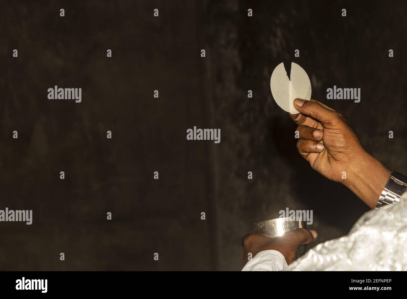 Hand holding a piece of bread during the rite of a worship Stock Photo ...