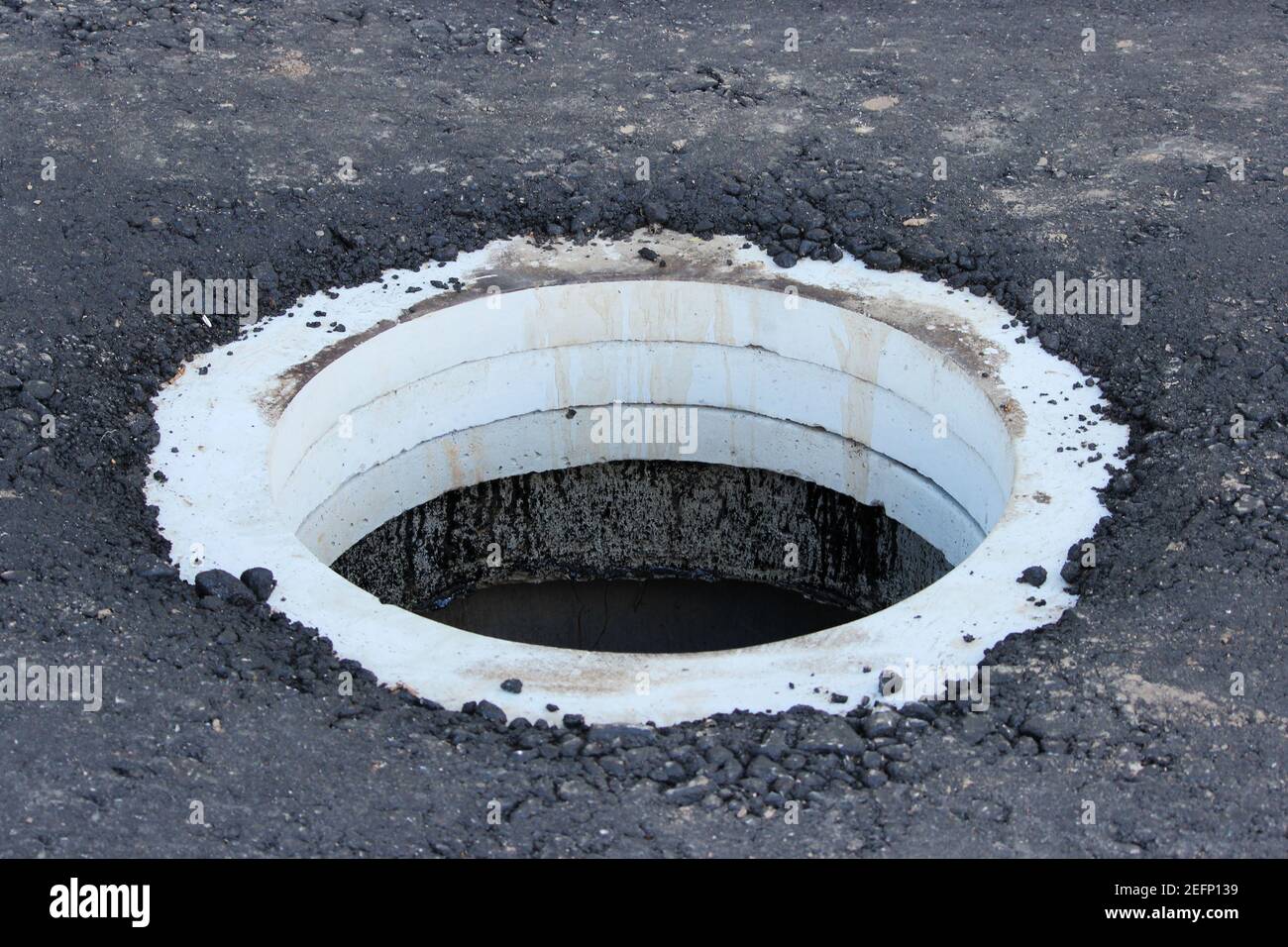 concrete ring from a storm drain on an asphalt road. road repair and ...