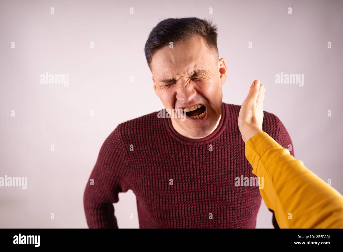 Crop person slapping scared man in face. Emotional male getting slapped ...