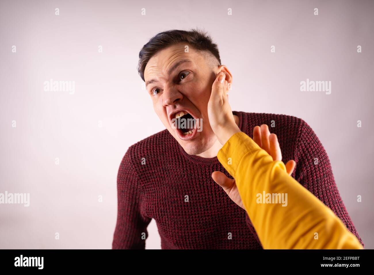 Crop person slapping scared man in face. Emotional male getting slapped ...