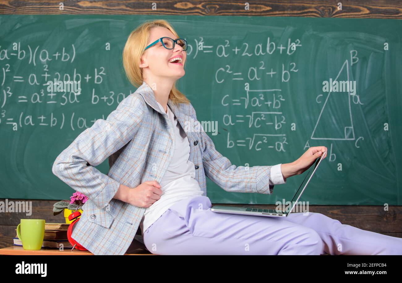 Woman teacher hold laptop sit table classroom chalkboard background ... Woman teacher hold laptop sit table classroom chalkboard background ...