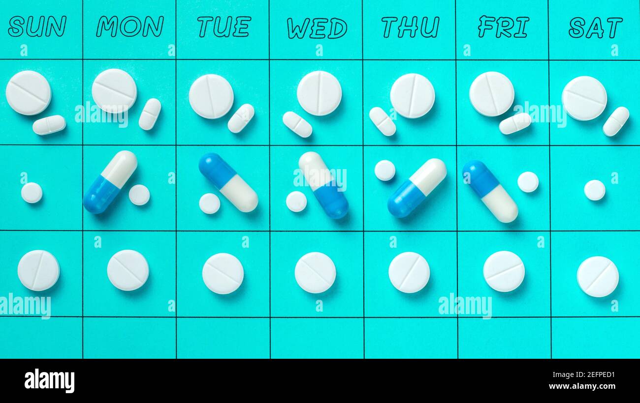Daily and weekly medication schedule. Various pills and capsules on a ...