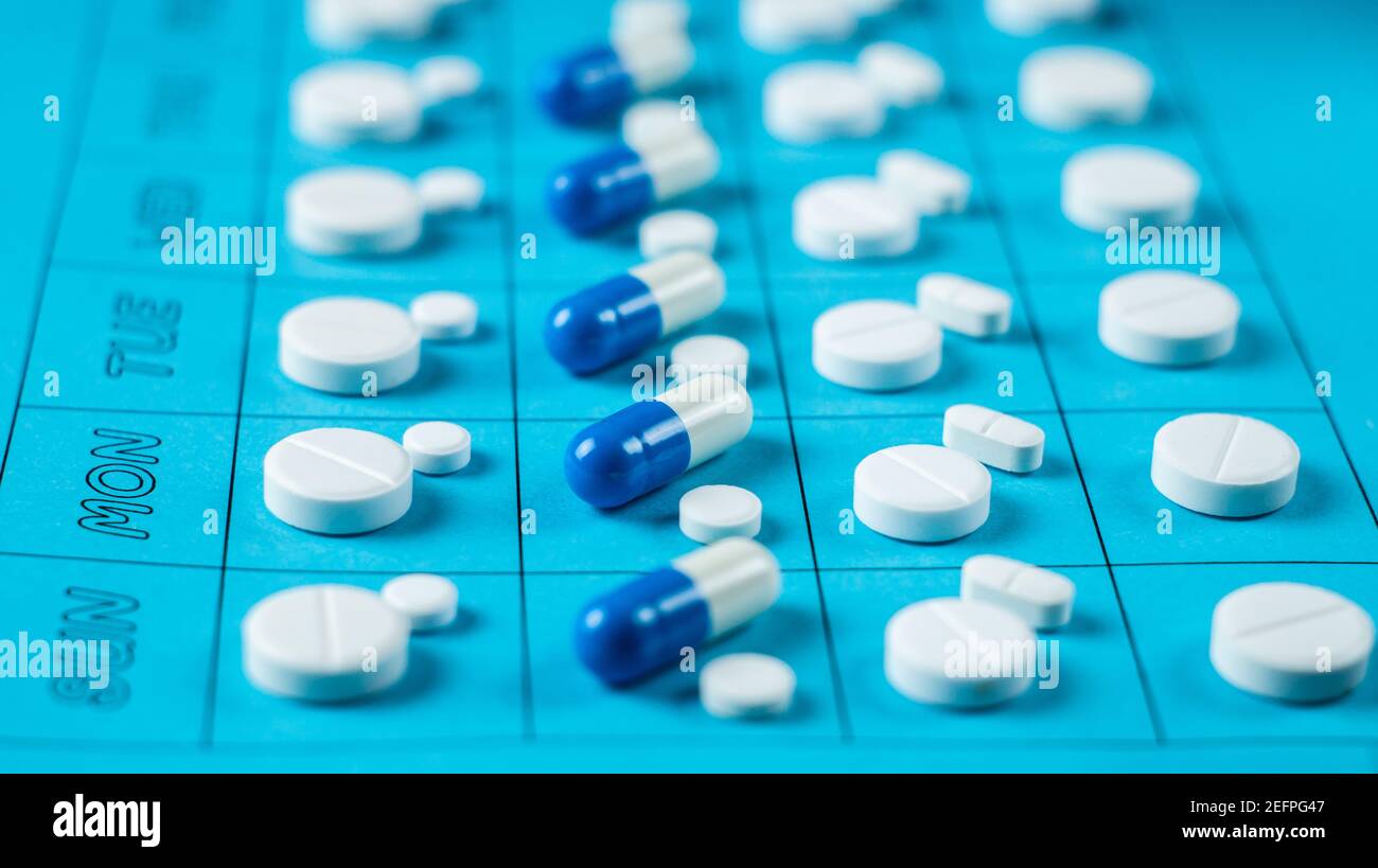 Daily and weekly medication schedule. Various pills and capsules on a ...