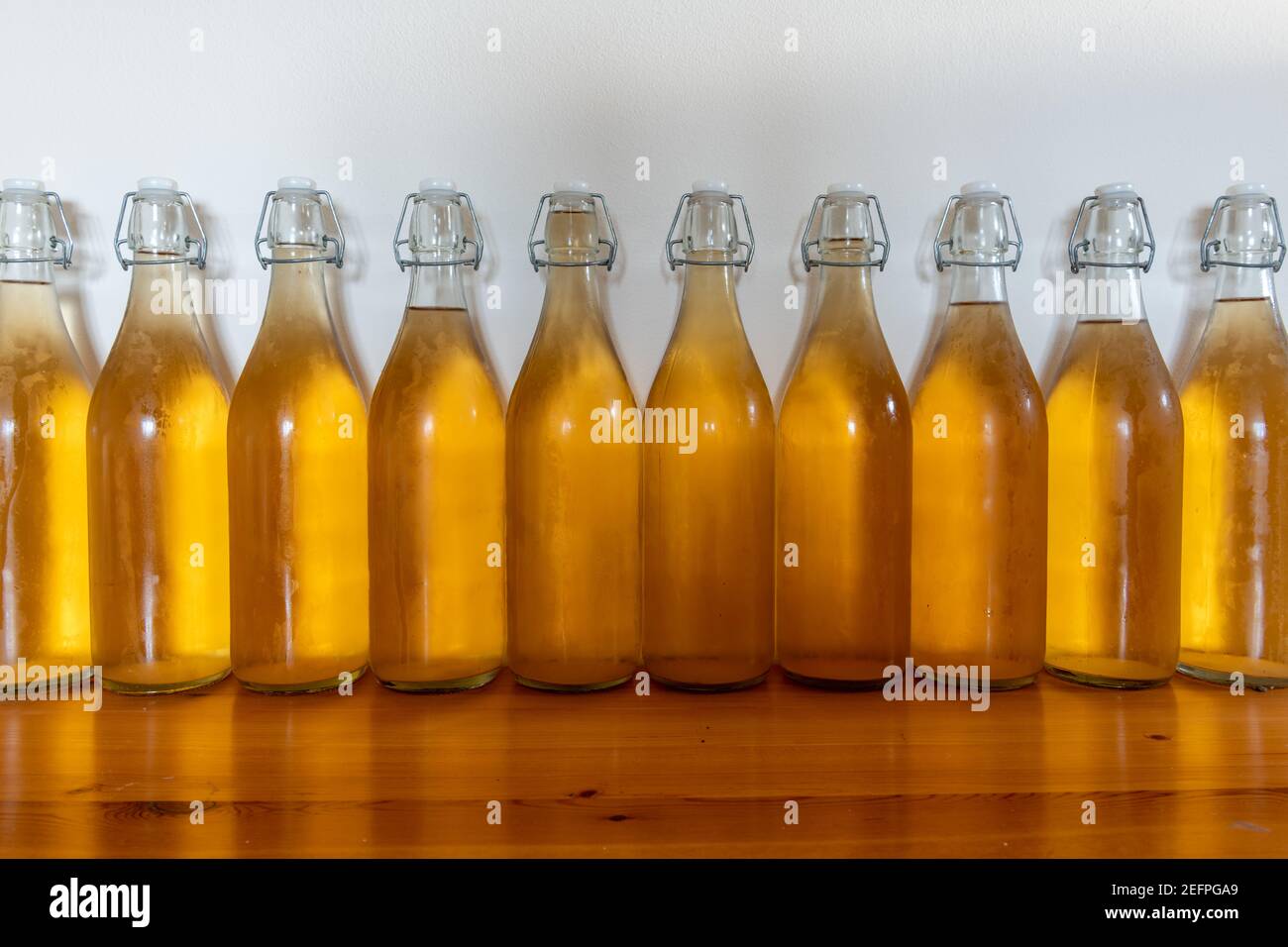 Close up of a row of flip top bottles of home made cider covered in ...