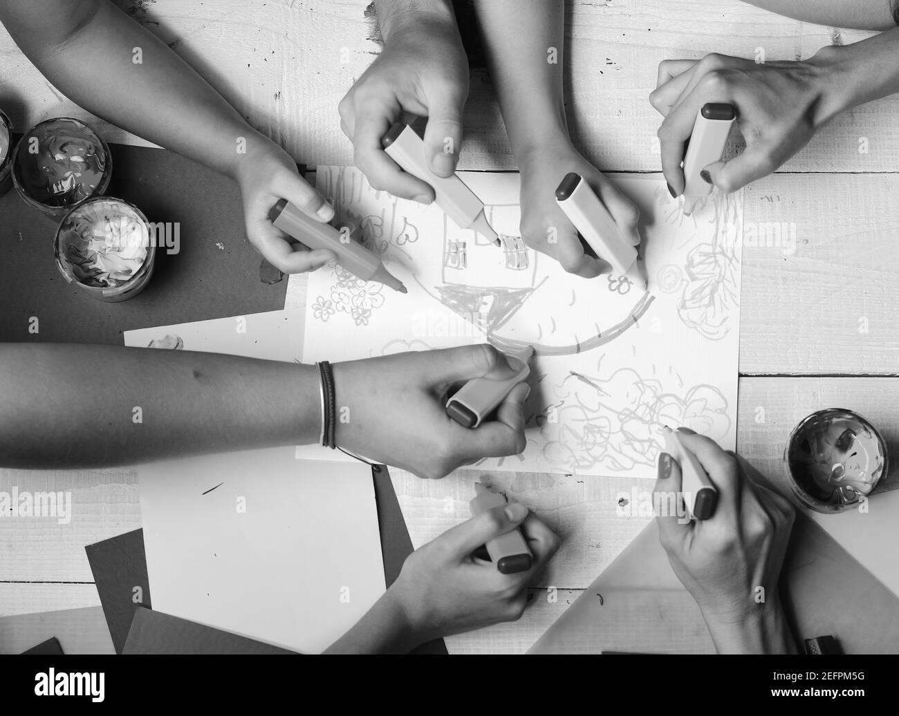 Hands hold colorful markers and draw kids illustration, top view ...