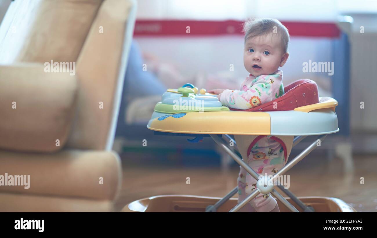 baby learning to walk in walker Stock Photo - Alamy