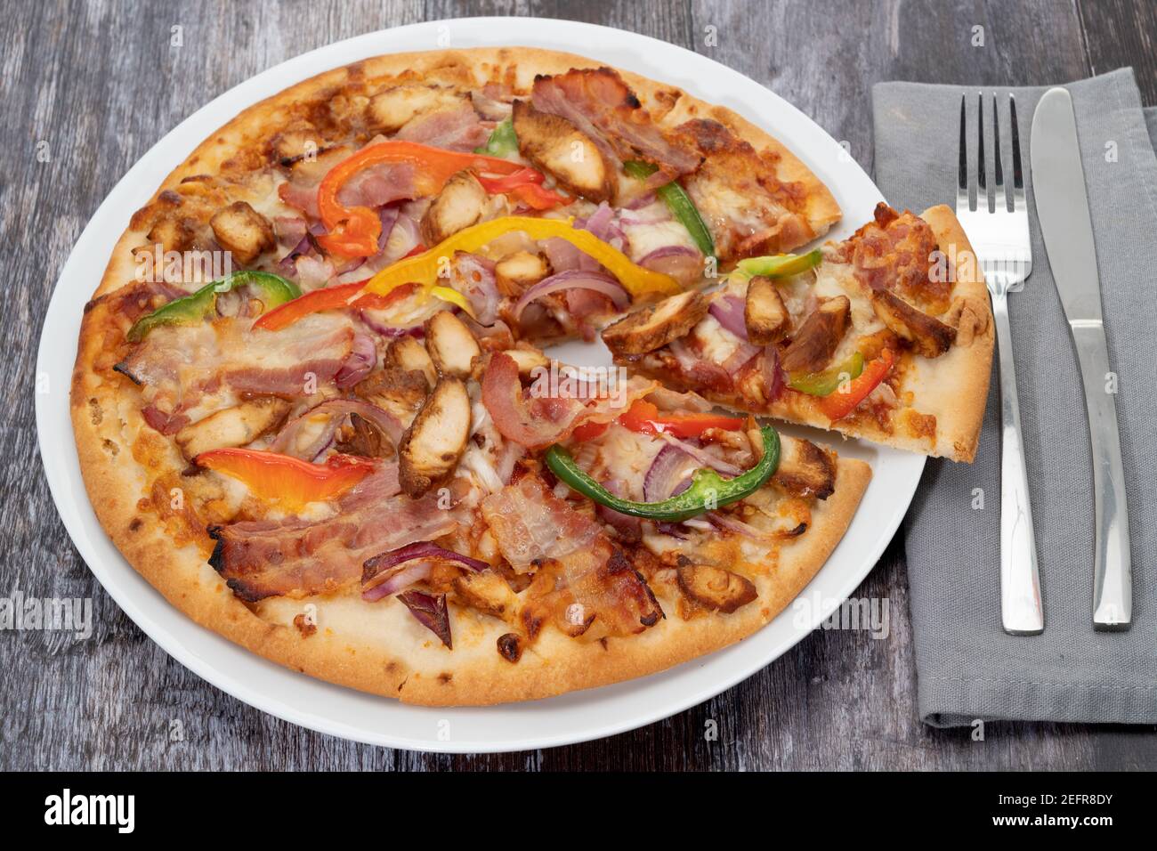 A meat feast pizza with a slice removed viewed from above Stock Photo ...