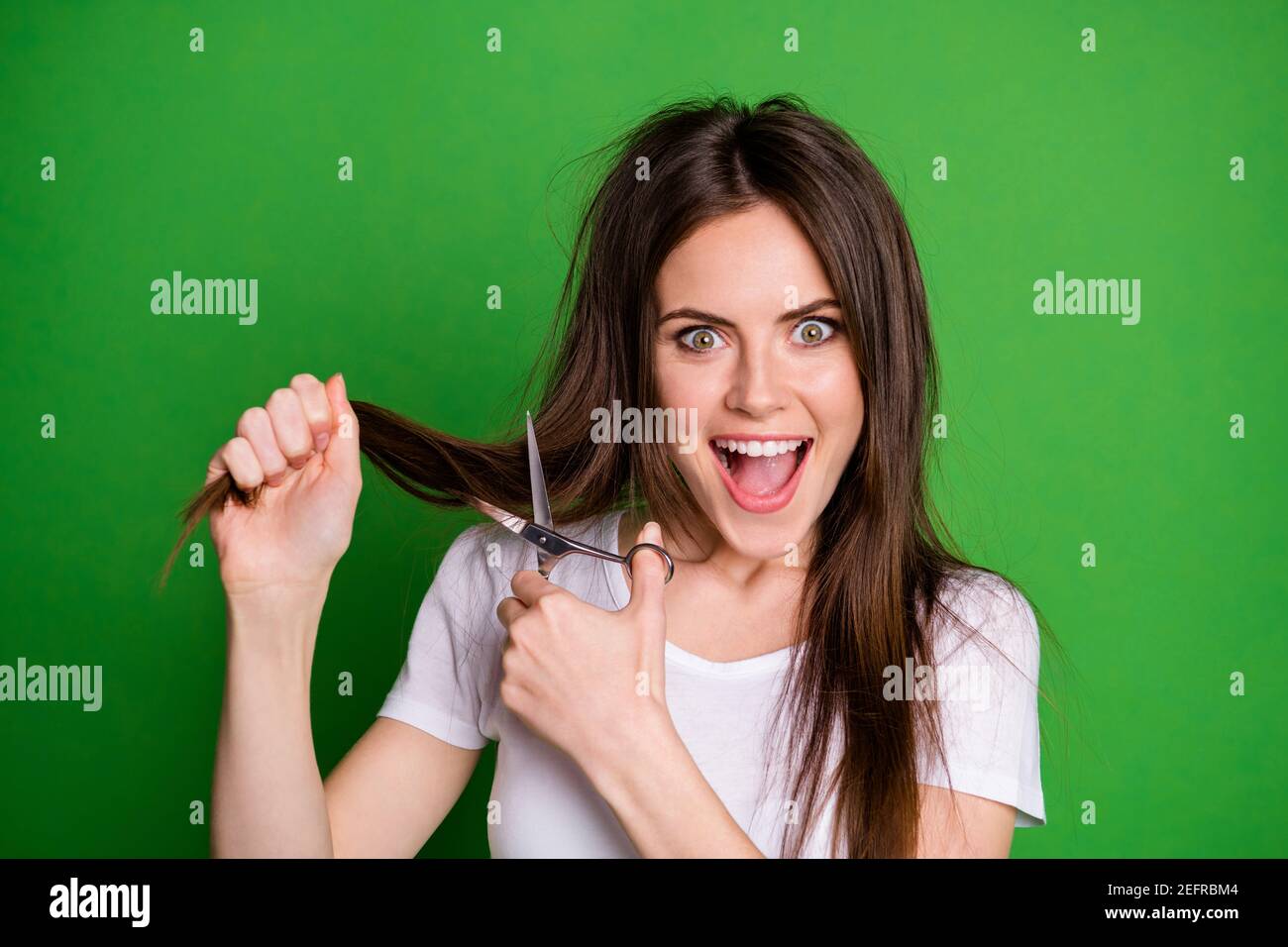 Photo portrait of crazy girl cutting hair with scissors isolated on ...