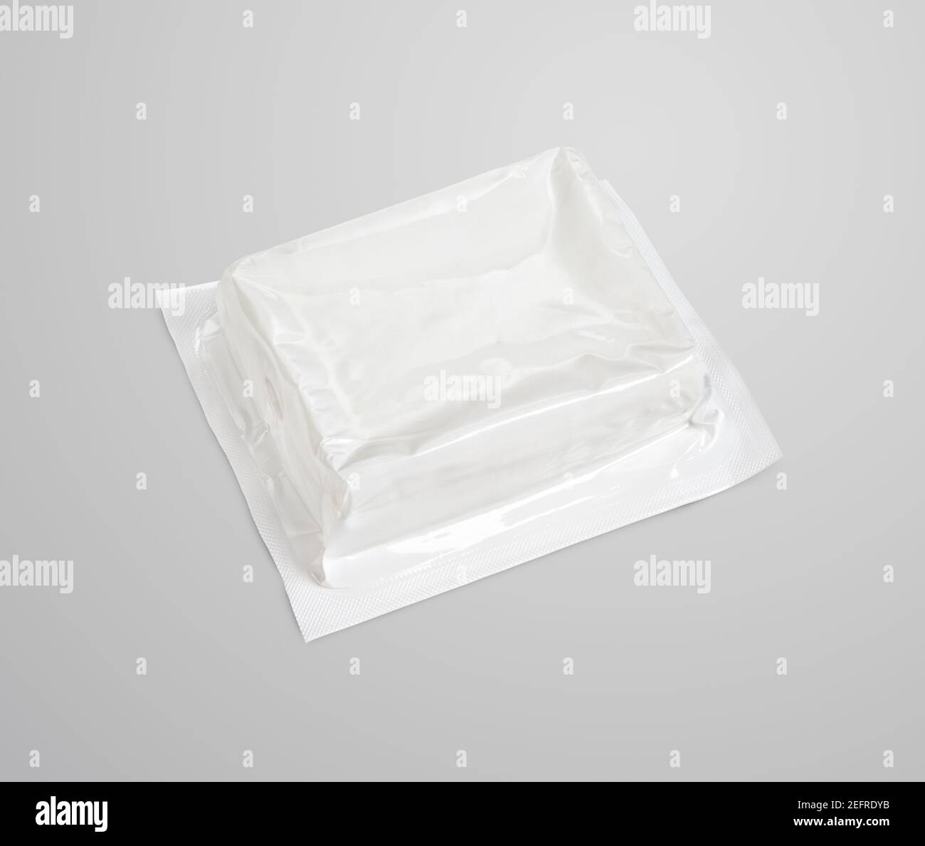 Block of white vacuum soft wrap box package on gray background with ...