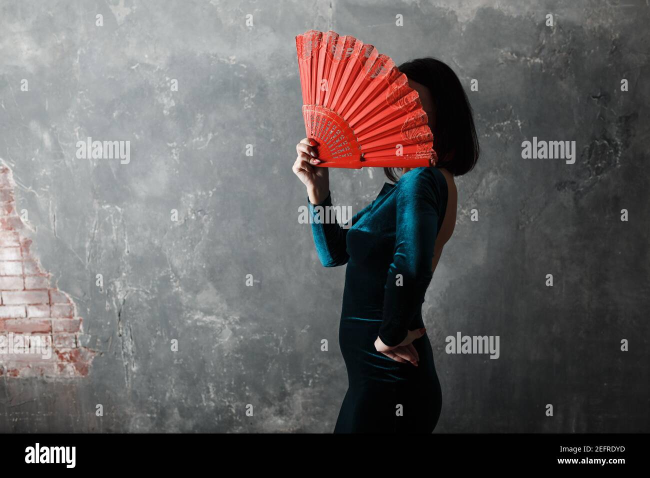 Young adult spanish woman dancing flamenco on gray vintage studio ...