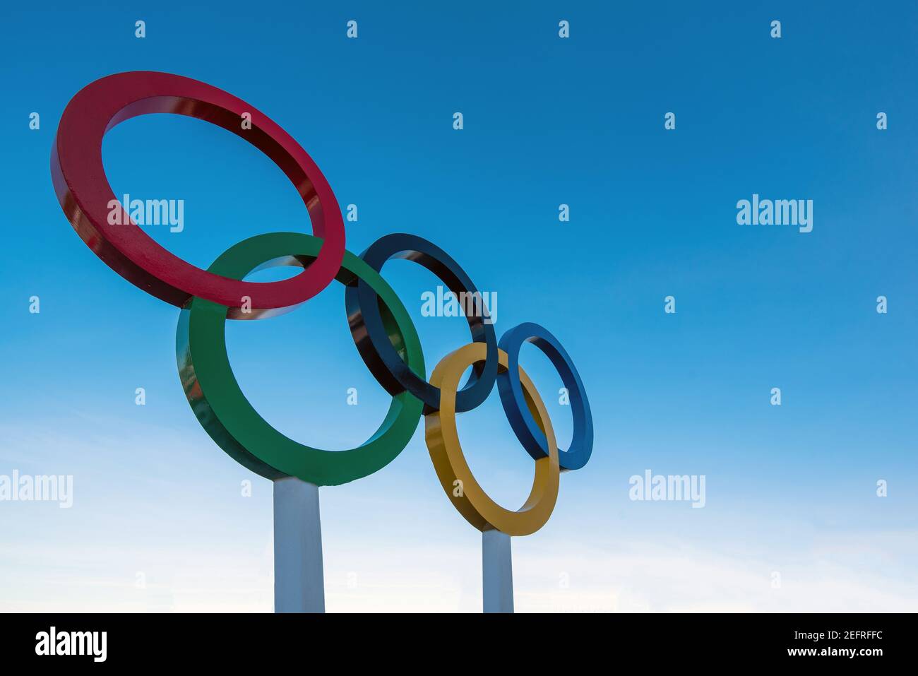 Five intertwined rings in blue, black, red, yellow and green on a blue ...