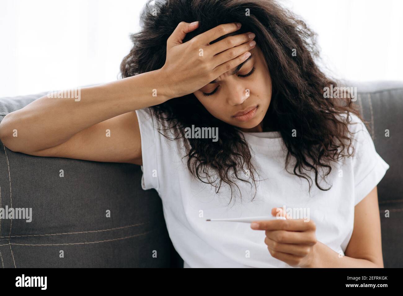 Sick african american girl sit on couch feel unhealthy, she looks at ...