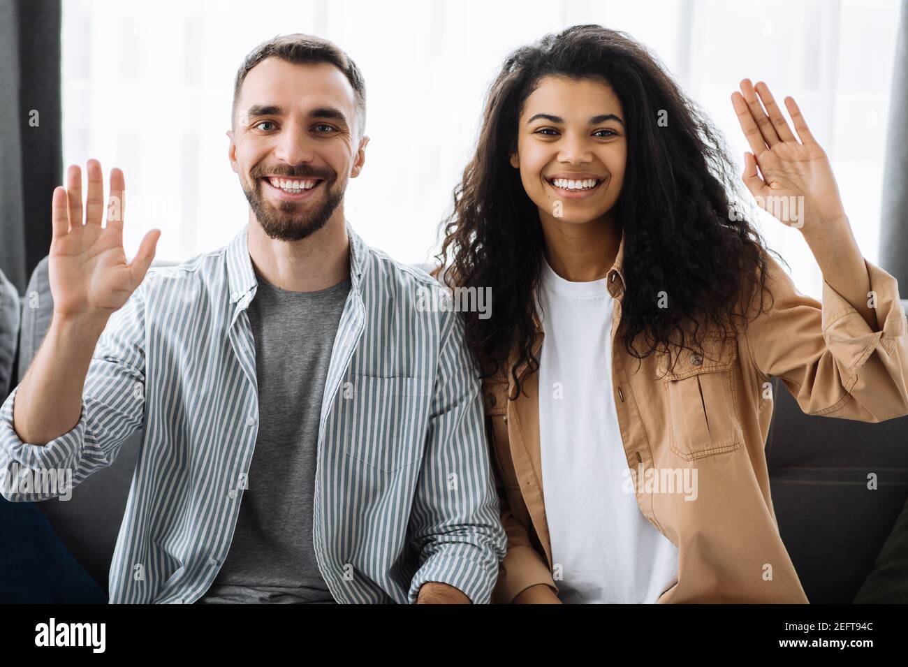 Two People Waving To Each Other