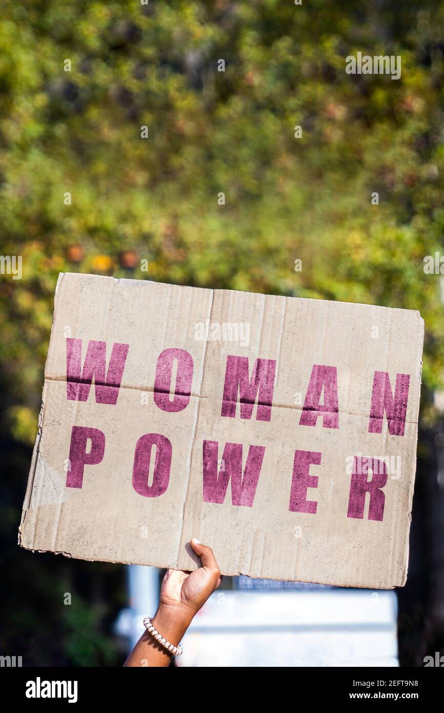 Woman power. Hand of a protester holding a banner calling for gender ...