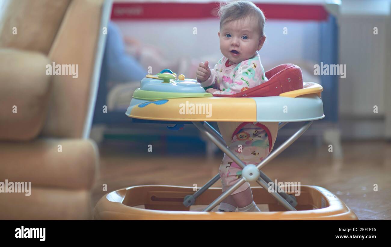 baby learning to walk in walker Stock Photo - Alamy