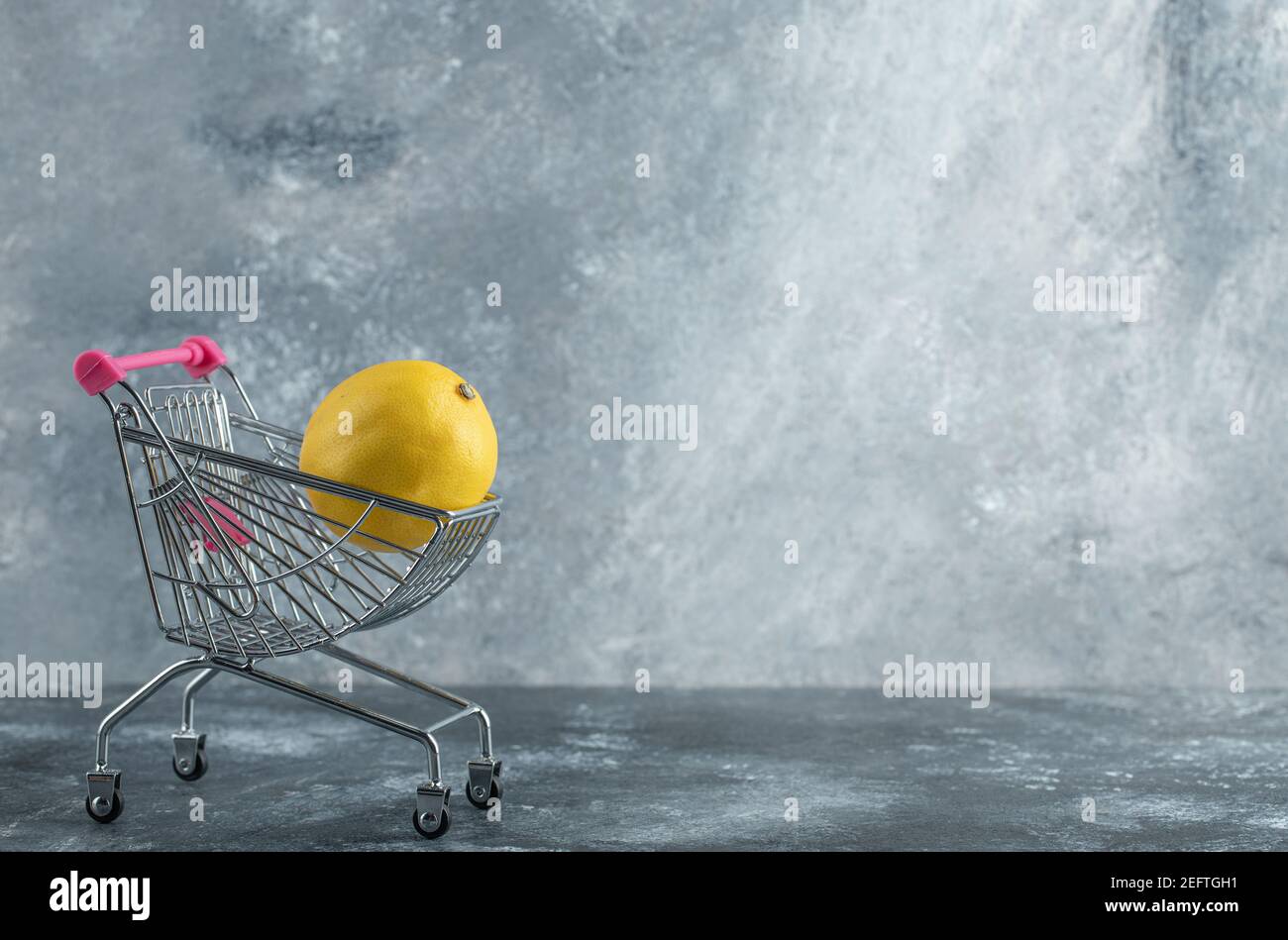 Sour lemon placed in small shopping cart Stock Photo - Alamy