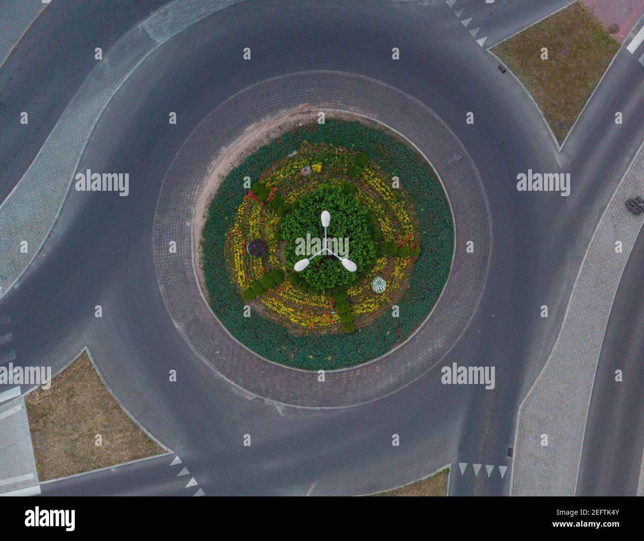 Roundabout at city streets with plants and high lamp at center Stock ...
