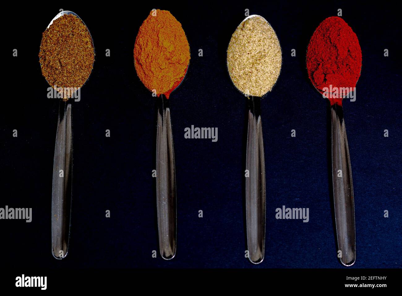 Four different spices in spoons Stock Photo - Alamy