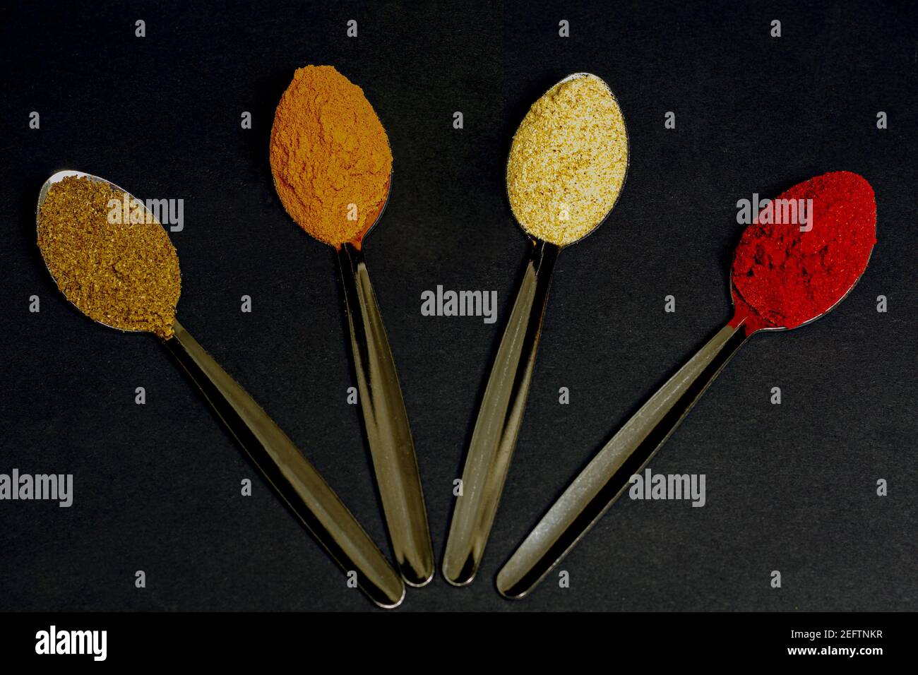 Four different spices in spoons Stock Photo - Alamy