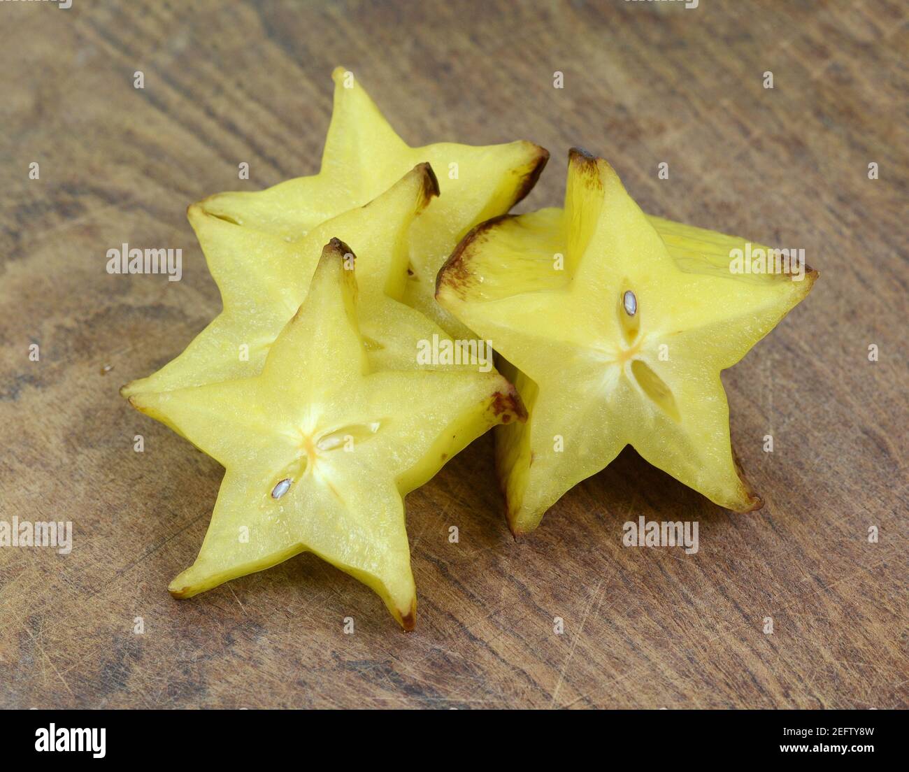 Star shaped slices of carambola fruit on a wooden background. Carambola ...