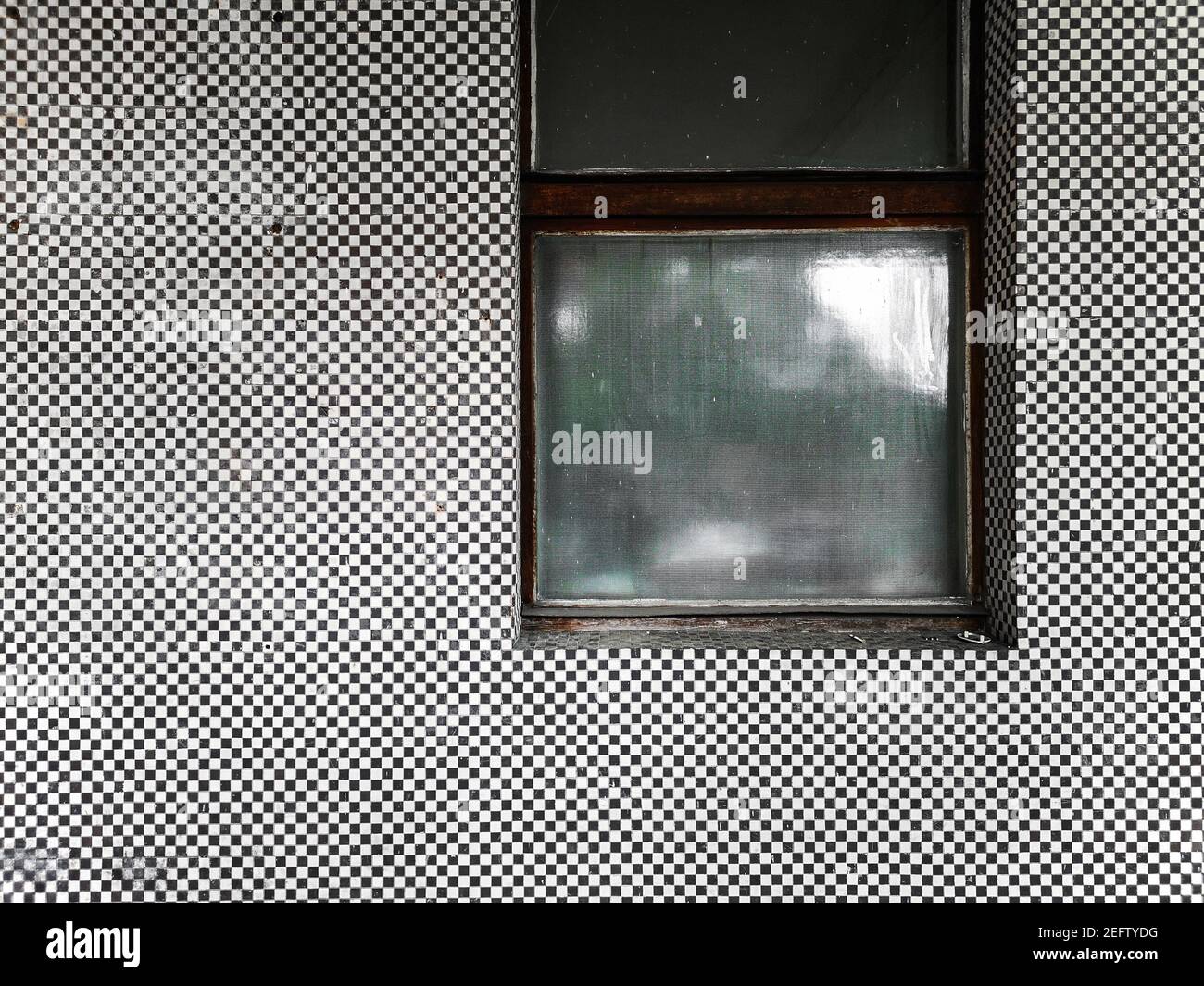 Old covered window at facade of mosaic black and white tiles Stock ...