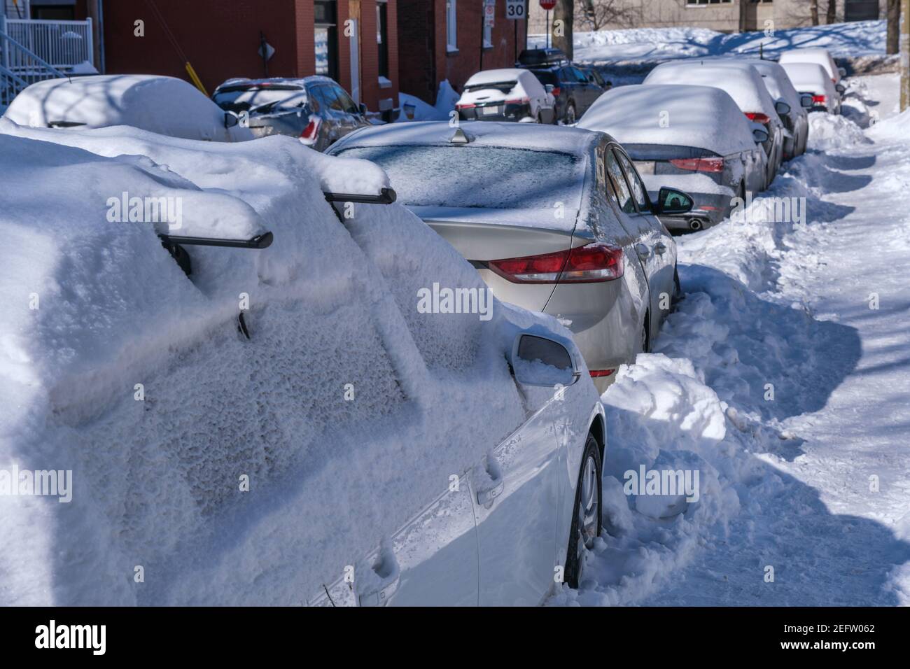 City street and cars covered in snow after snowfall in Montreal, Canada ...