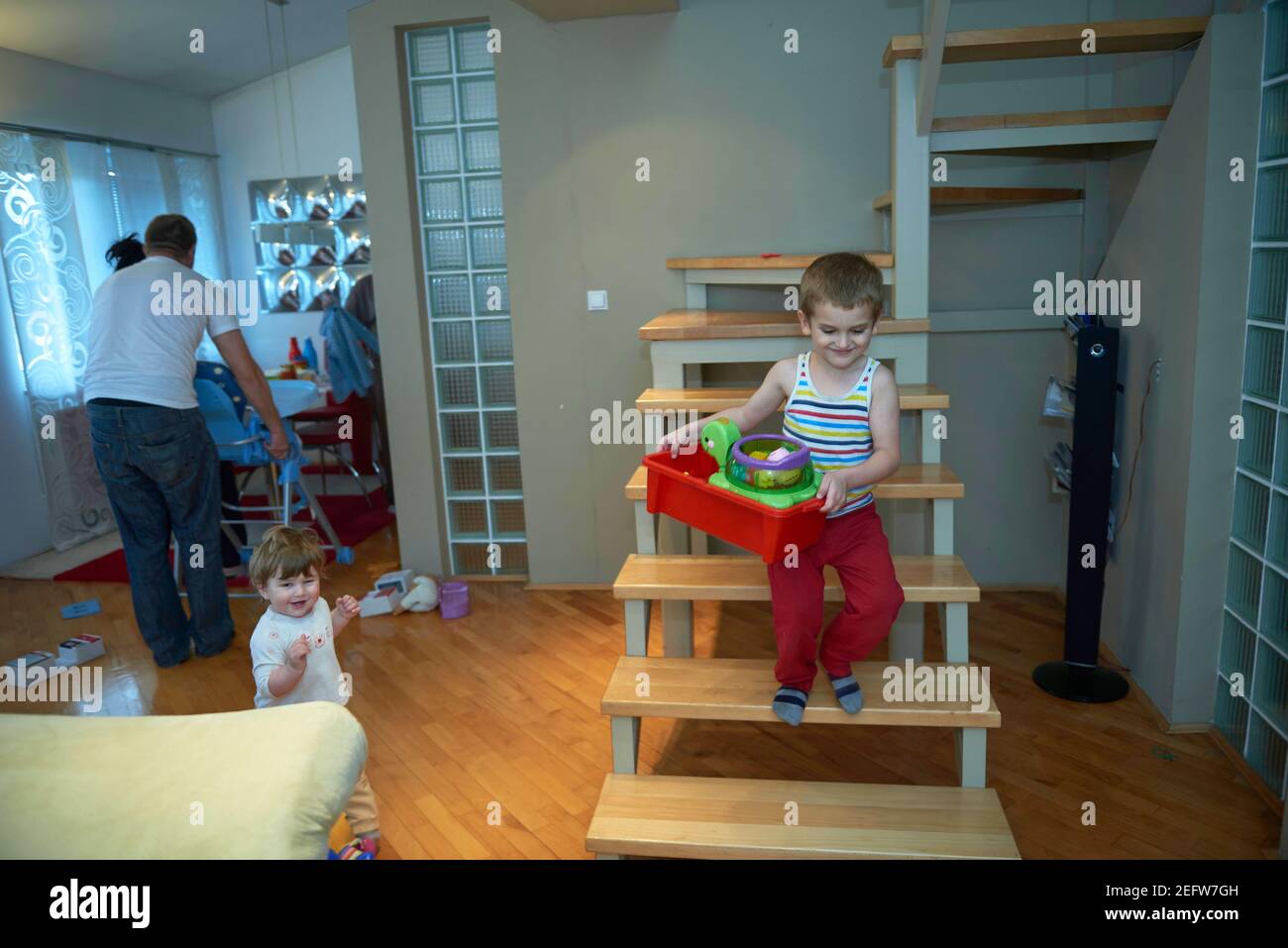 Little child playing and bring toys to sister Stock Photo - Alamy