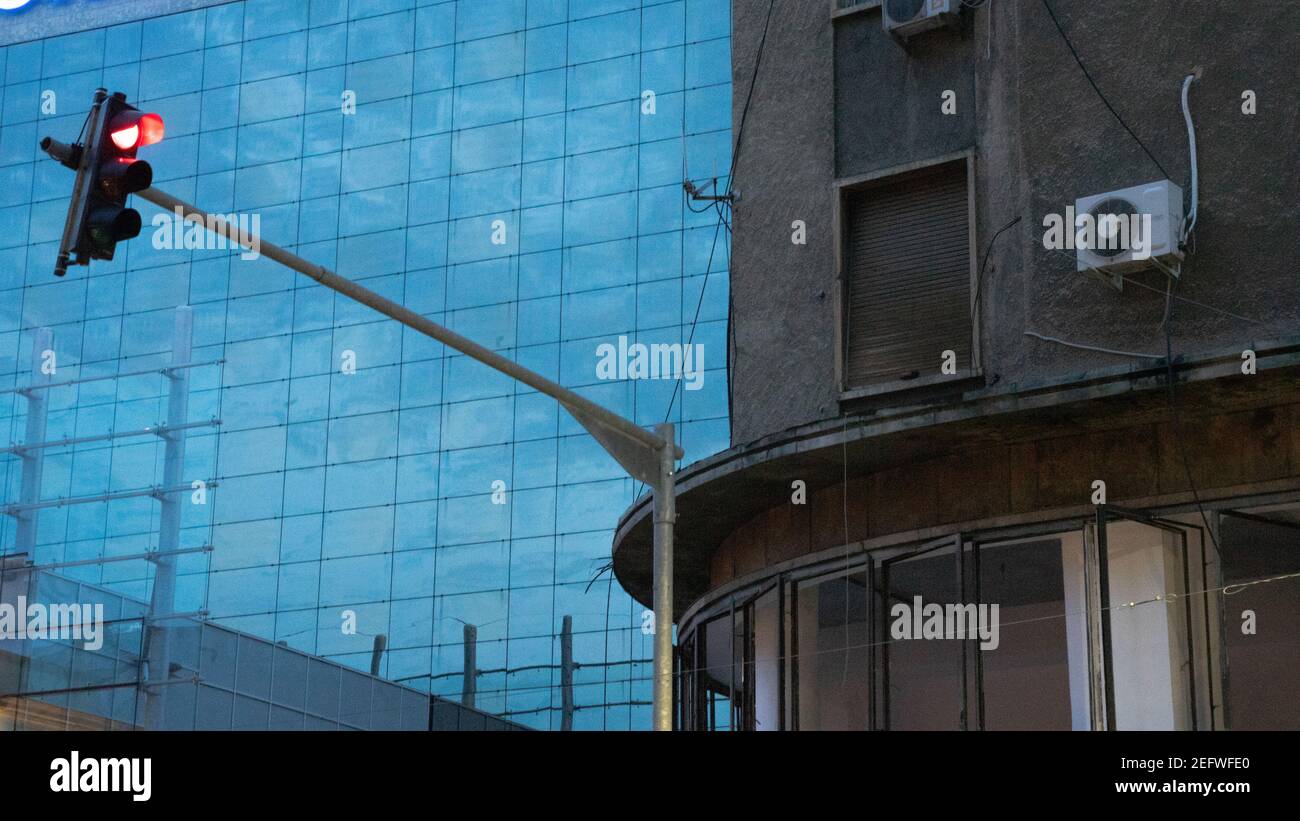 Bucharest, Romania. Hanging red traffic light against the blue glass ...