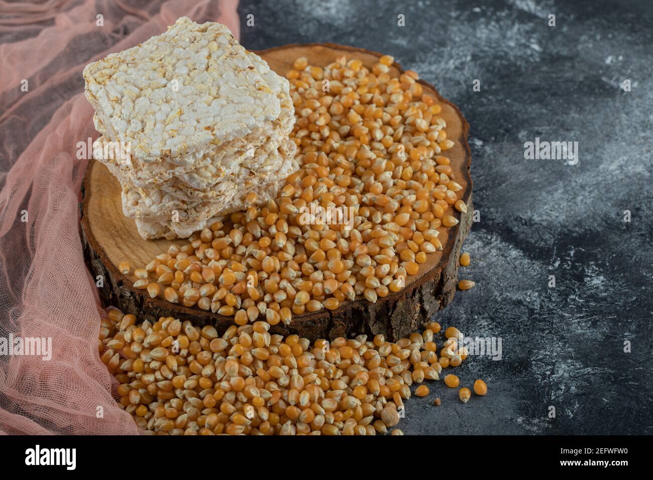Crispbread and raw corn seeds on wood piece Stock Photo - Alamy