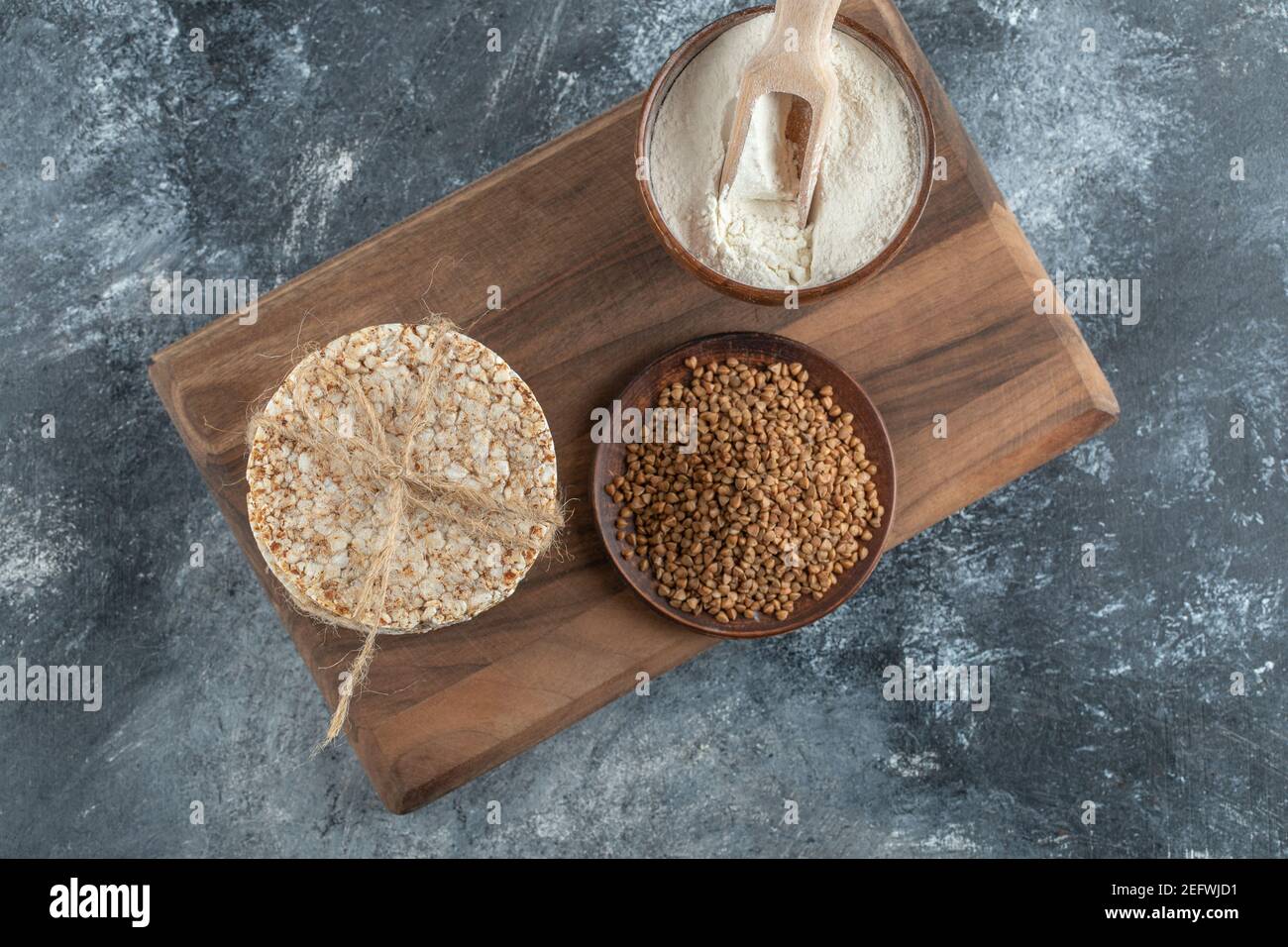 Stack of rice cakes, bowl of flour and buckwheat on wooden board Stock ...