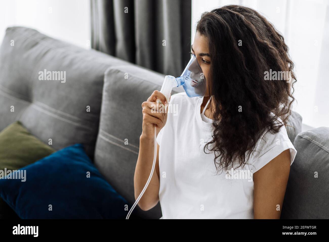 Close-up photo of sick african american woman with an inhaler ...