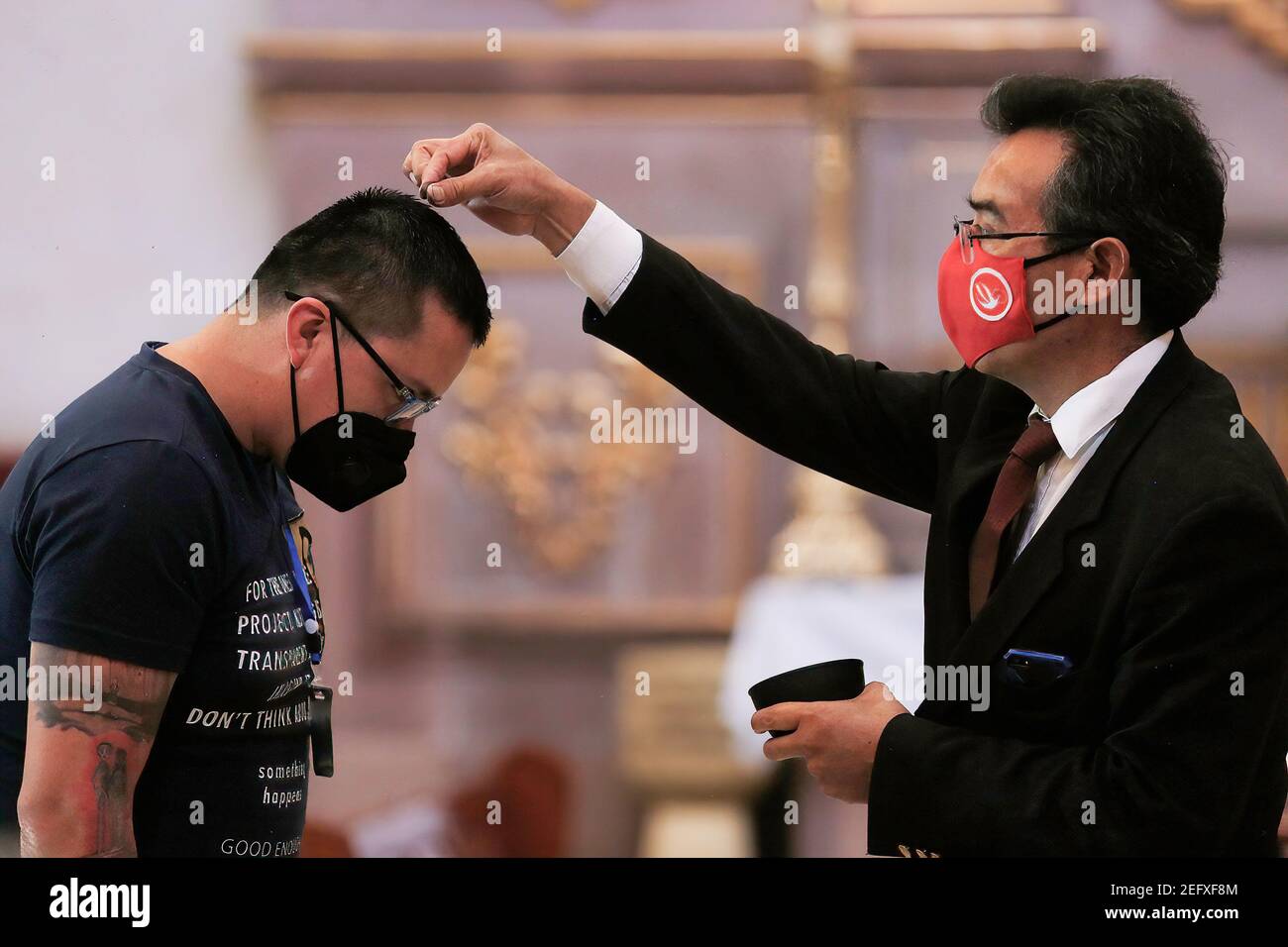 A priest applies ash on a man's head at a catholic church. Ash ...