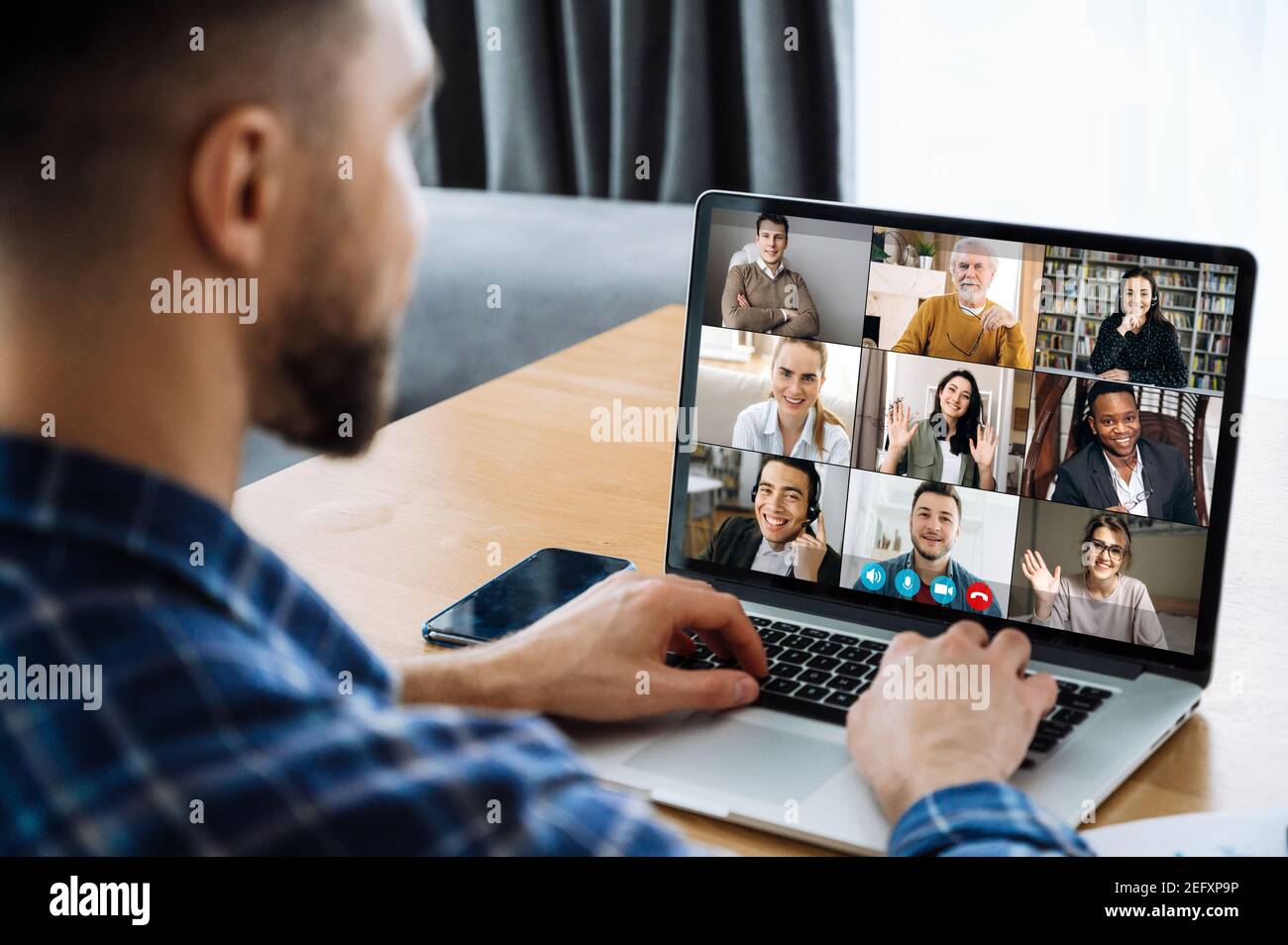 Over shoulder view to a laptop screen with many multiracial successful ...