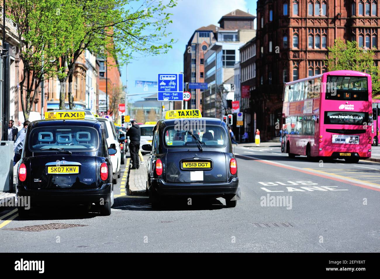 Belfast, Northern Ireland. A double-decker bus passes taxis in a queue ...