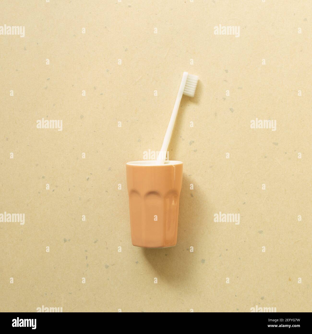 Toothbrush in ceramic cup on beige background. Bathroom. top view Stock ...