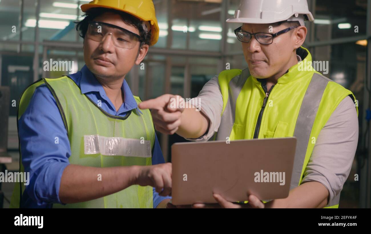 Two factory industrial workers technician or engineer and manager wear ...