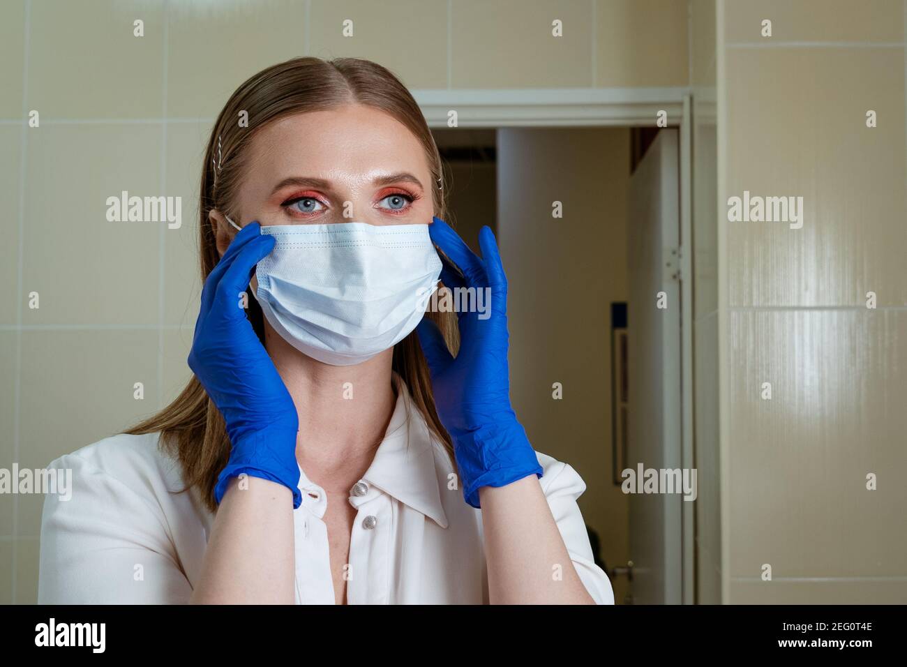 Woman doctor putting on protective mask Stock Photo - Alamy
