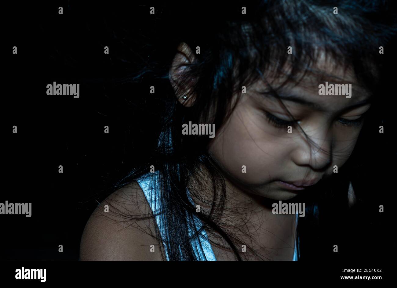 Powerful shot of a sad asian child. Female asian child sad dark scene ...