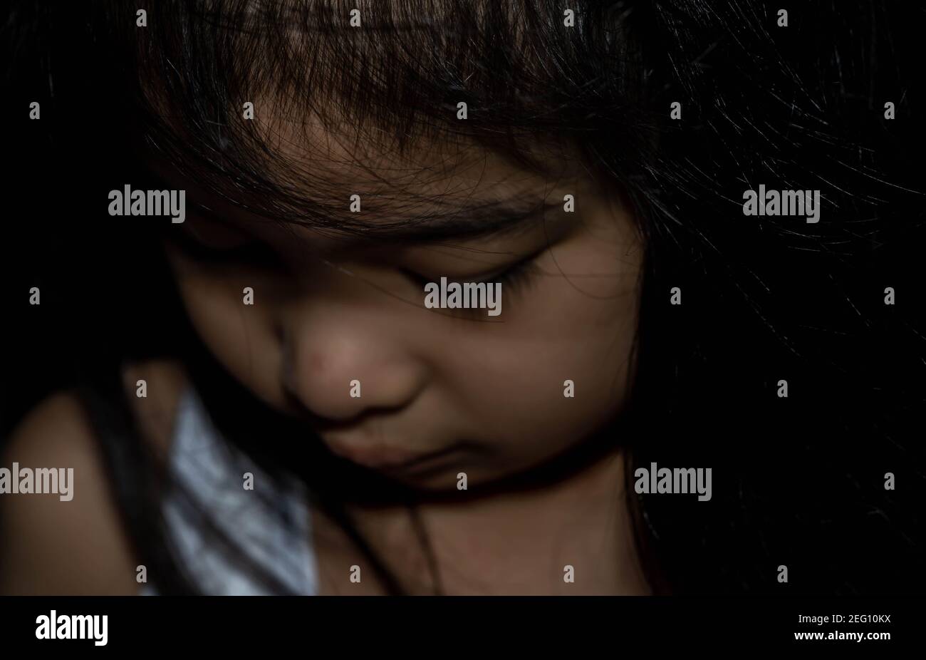 Powerful shot of a sad asian child. Female asian child sad dark scene ...