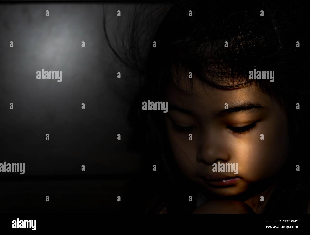 Powerful shot of a sad asian child. Female asian child sad dark scene ...