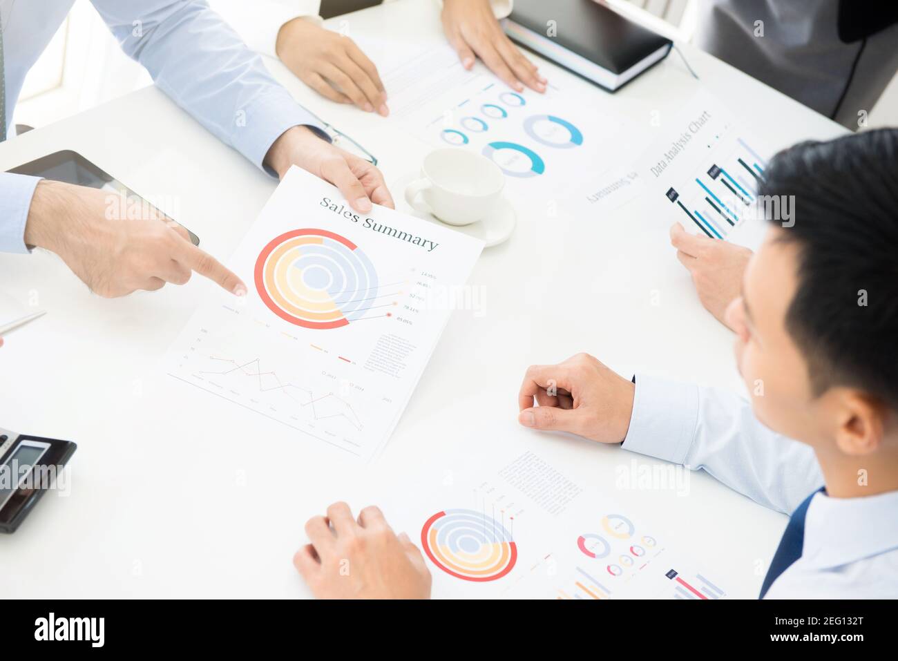 Business people discussing documents at meeting table Stock Photo - Alamy