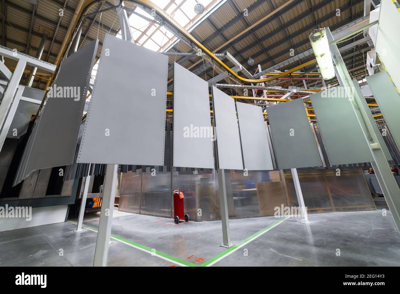 Powder coating line. Metal panels are suspended on an overhead conveyor ...