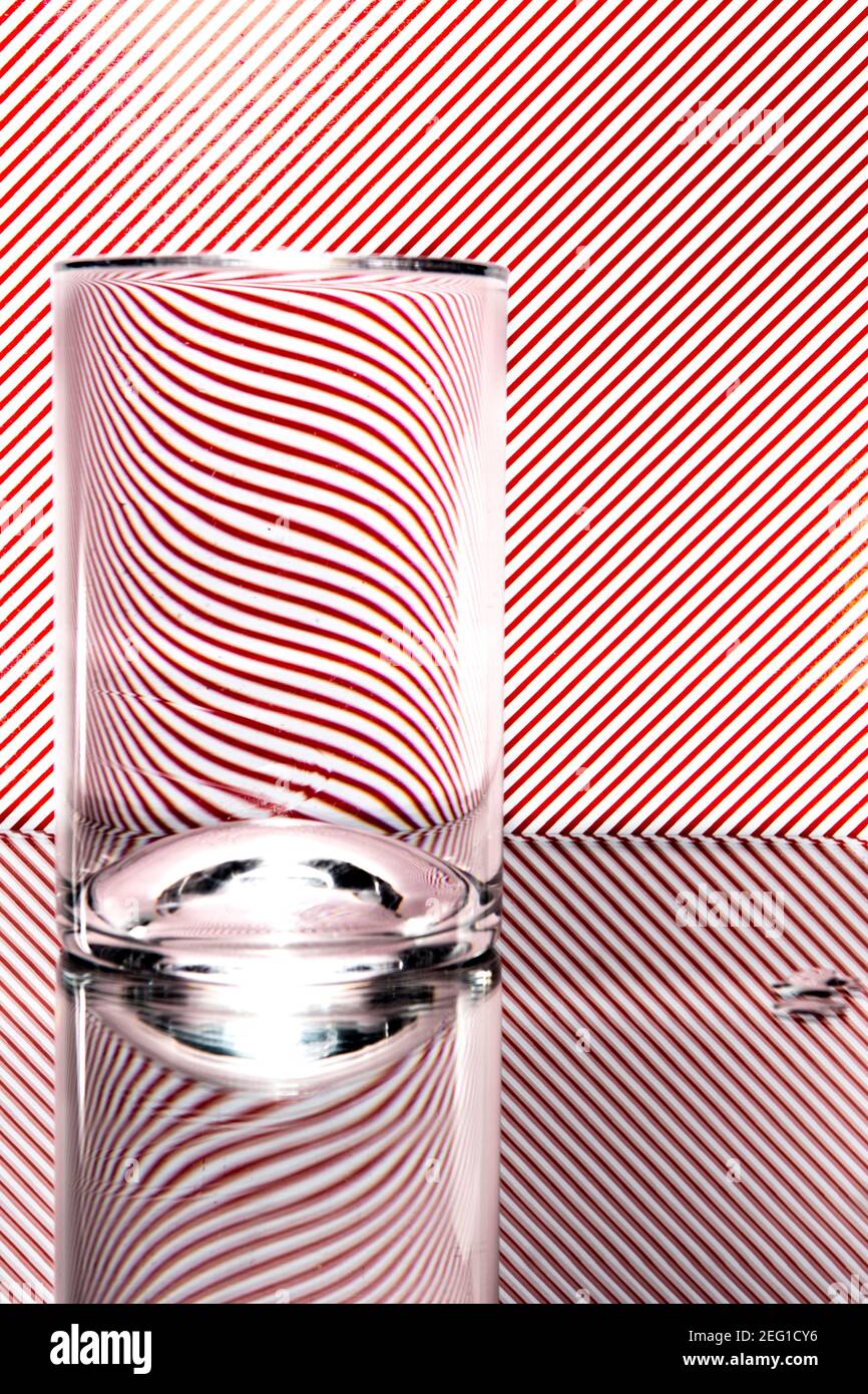 refraction of light by a wine glass on a red and white striped ...