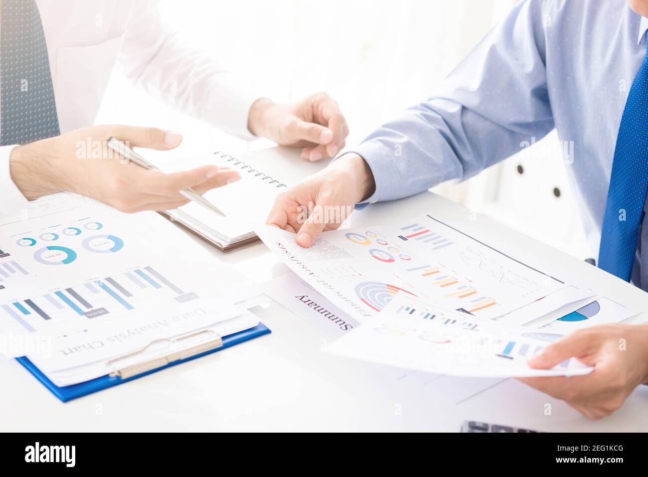 Two businessmen discussing documents at meeting table Stock Photo - Alamy