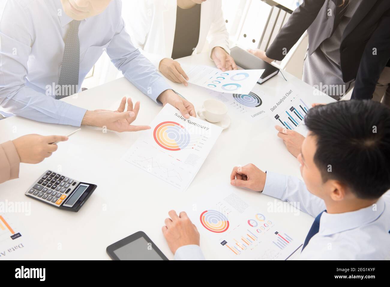 Business people discussing documents at meeting table Stock Photo - Alamy