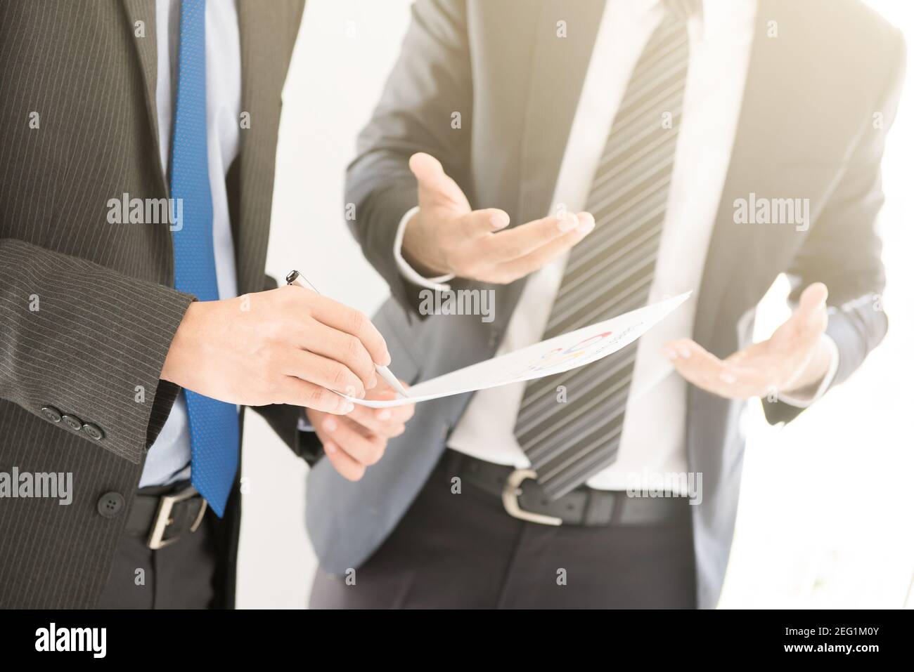 Two businessmen discussing document Stock Photo - Alamy