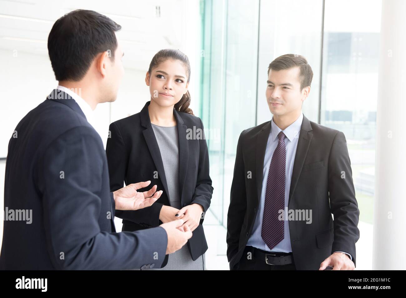Businesspeople talking in office building hallway Stock Photo - Alamy